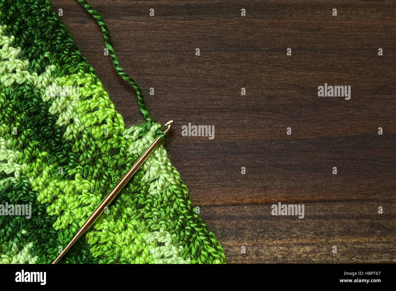 Crochet handicraft, making a place mat out of green yarn with a pattern ...