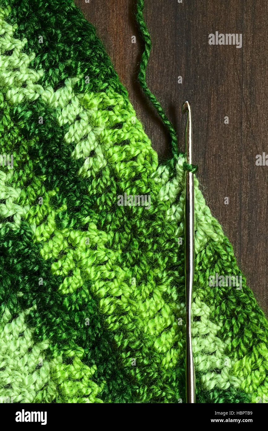 Crochet handicraft, making a place mat out of green yarn with a pattern ...