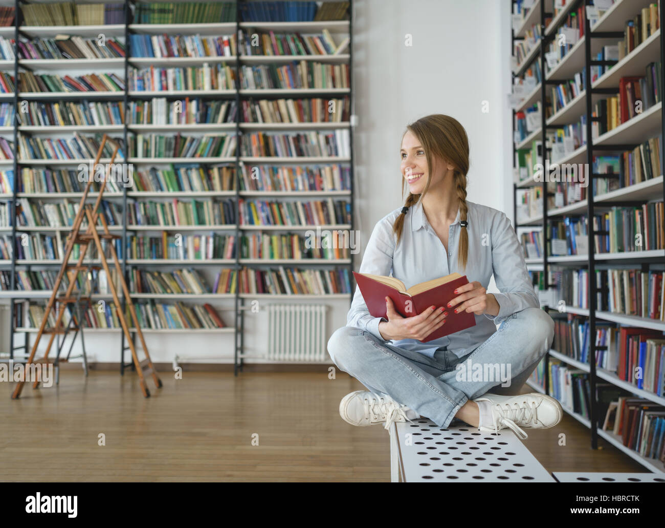 Young girl in library Stock Photo - Alamy