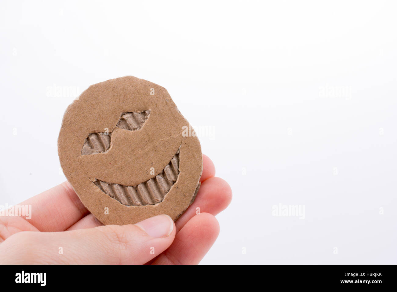 Hand holding a cardboard paper with smiley face Stock Photo - Alamy