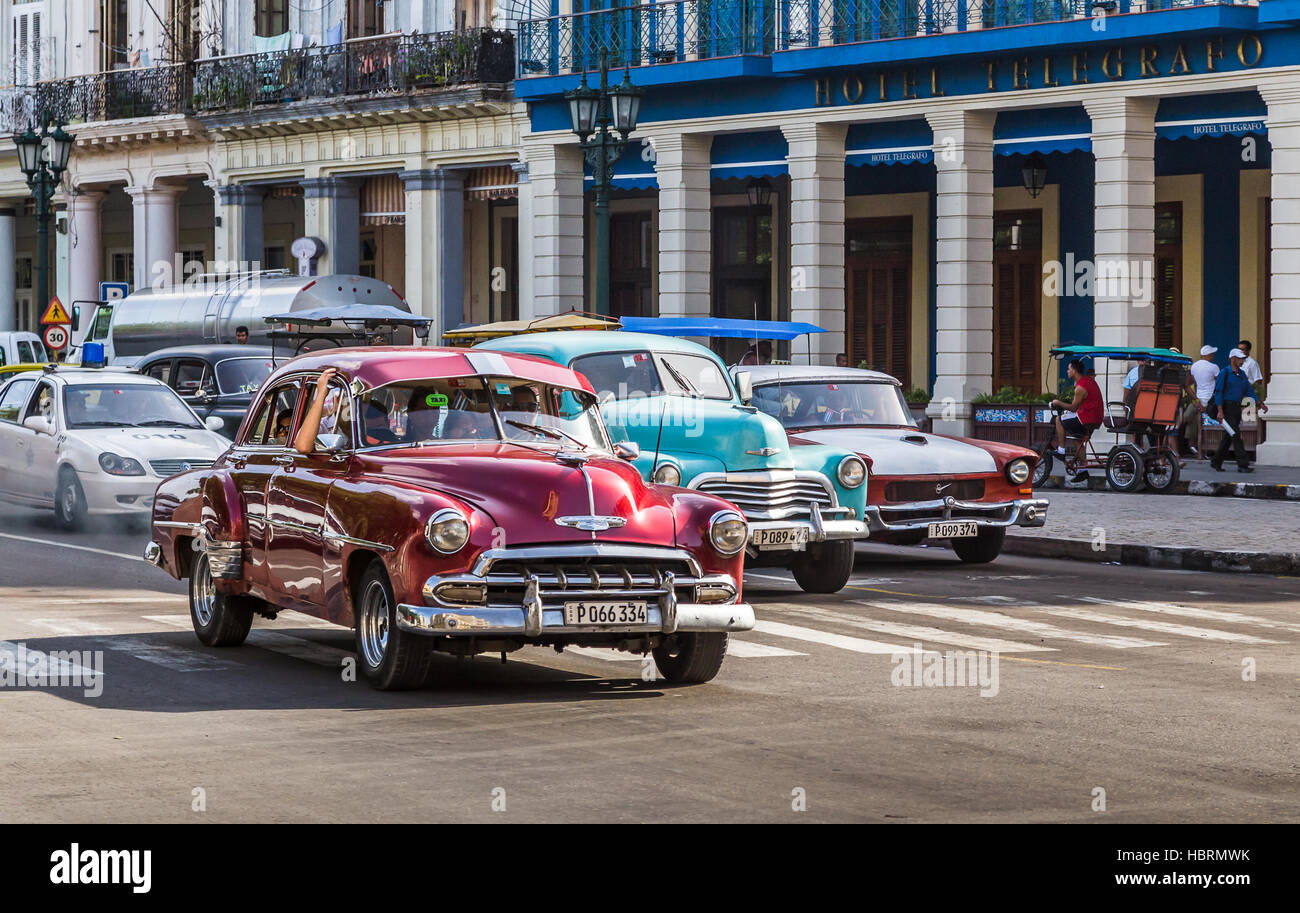 A frame full of old timers as they pull away from traffic lights on the ...