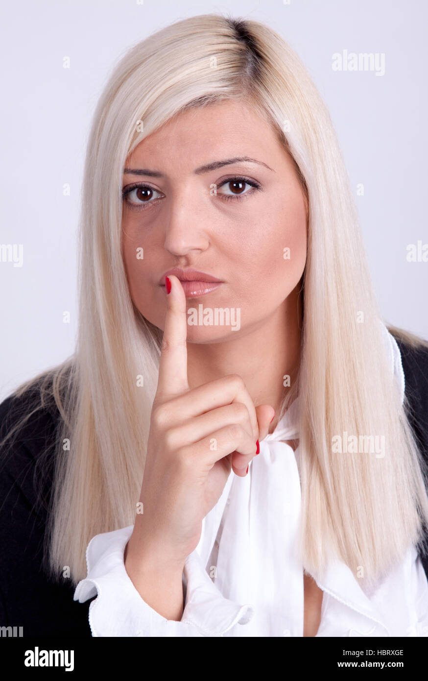 Young woman with finger on lips over white background Stock Photo - Alamy