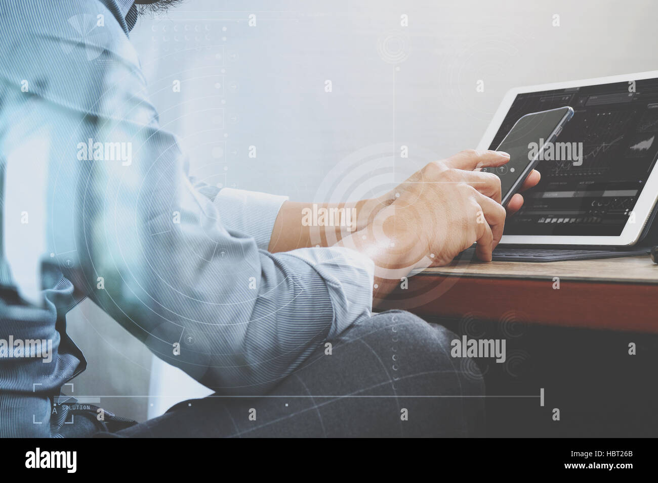 success businessman hand using smart phone,digital tablet docking smart keyboard on wood desk ...