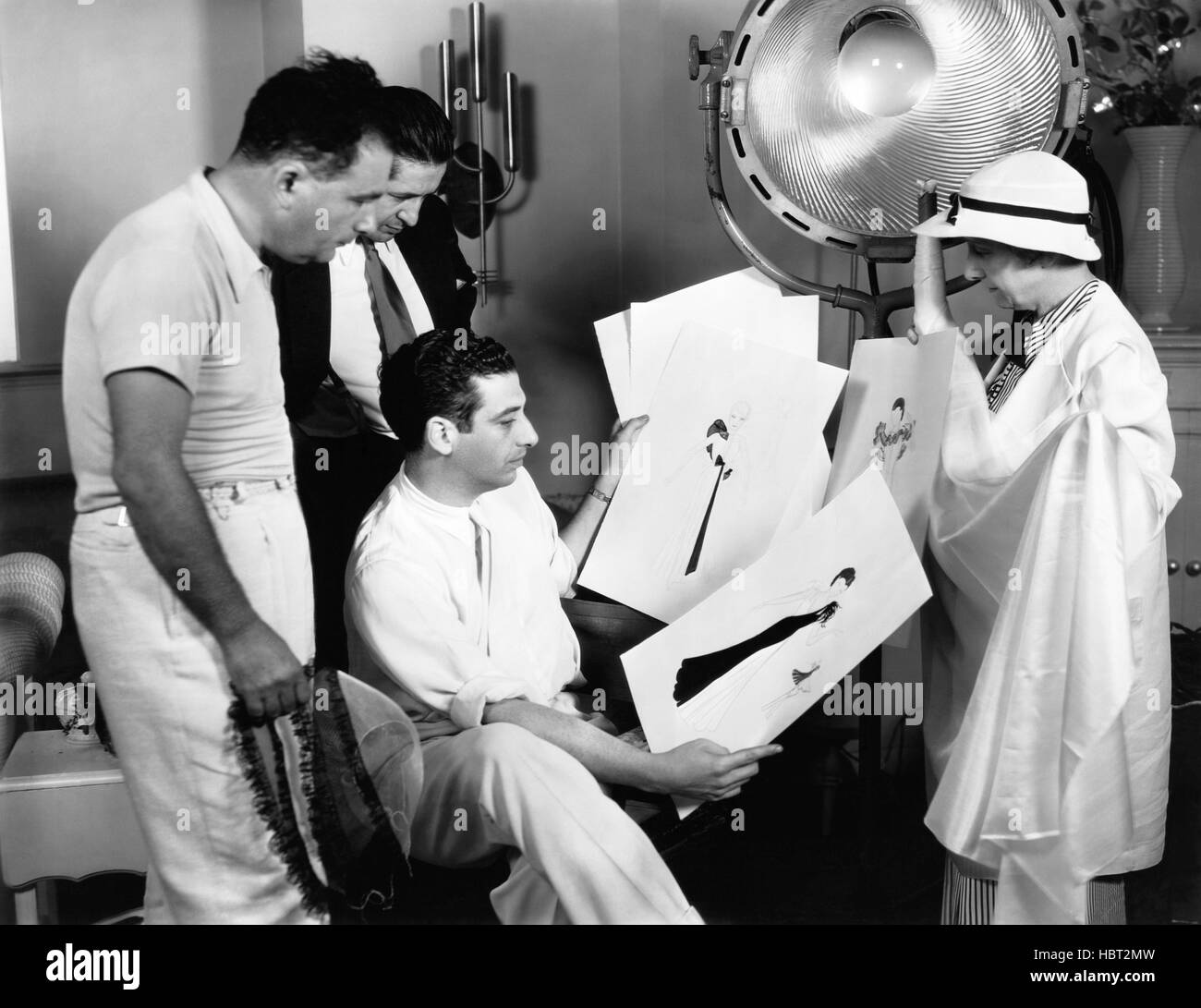 THE GAY DIVORCEE, director Mark Sandrich (seated) studying costume ...