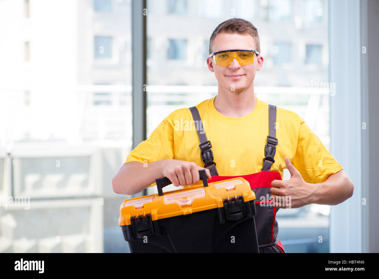 Young construction worker in yellow coveralls Stock Photo - Alamy