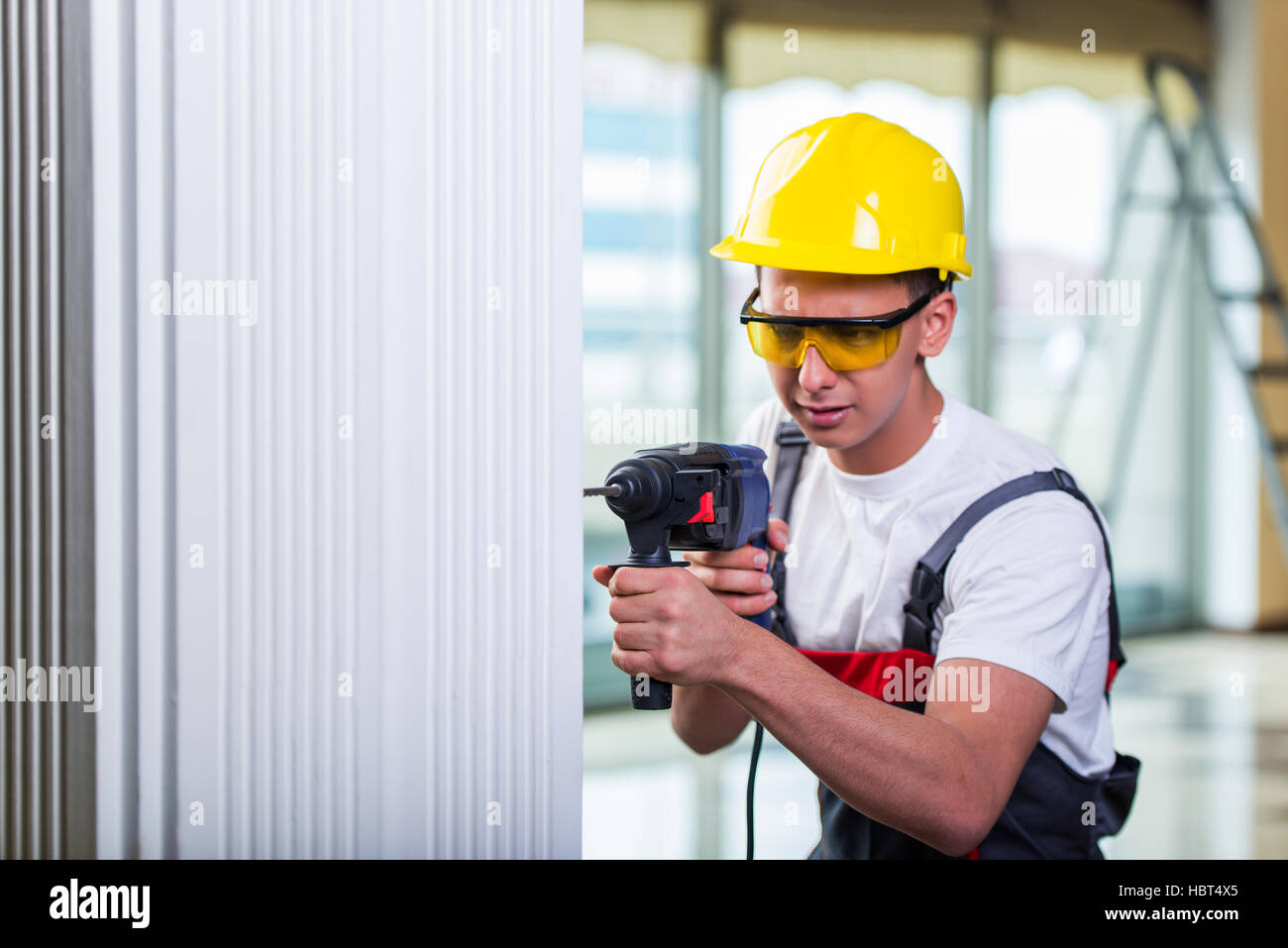 Man drilling the wall with drill perforator Stock Photo - Alamy