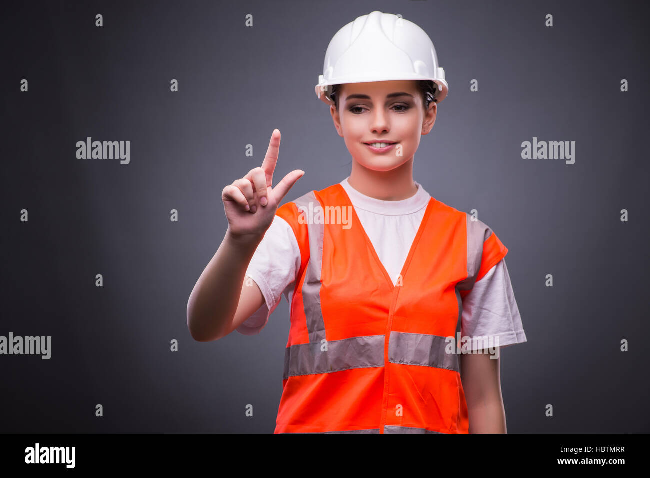 Cute construction worker pressing virtual buttons Stock Photo - Alamy