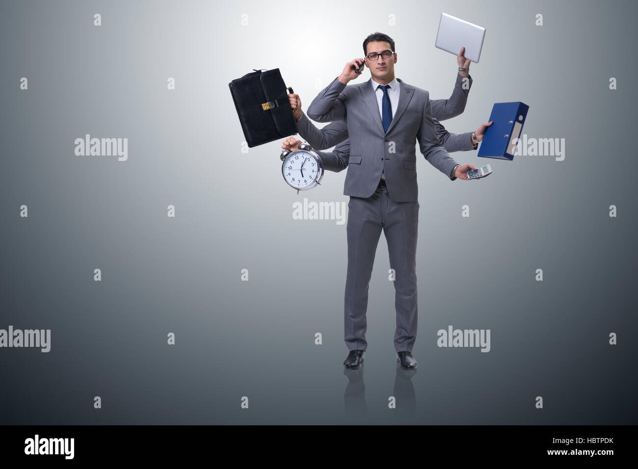 Young businessman in multitasking concept Stock Photo - Alamy