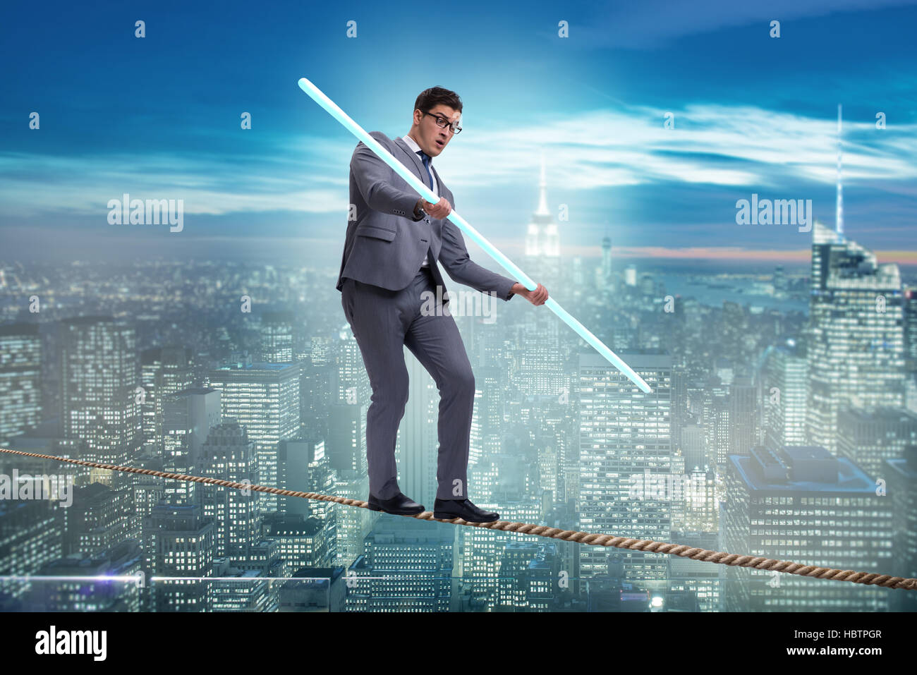 Businessman doing tightrope walking in risk concept Stock Photo - Alamy