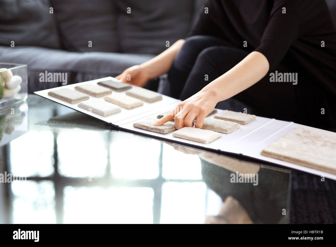 Shop carpets. Picker carpet. Woman in shop with carpets chooses carpet ...