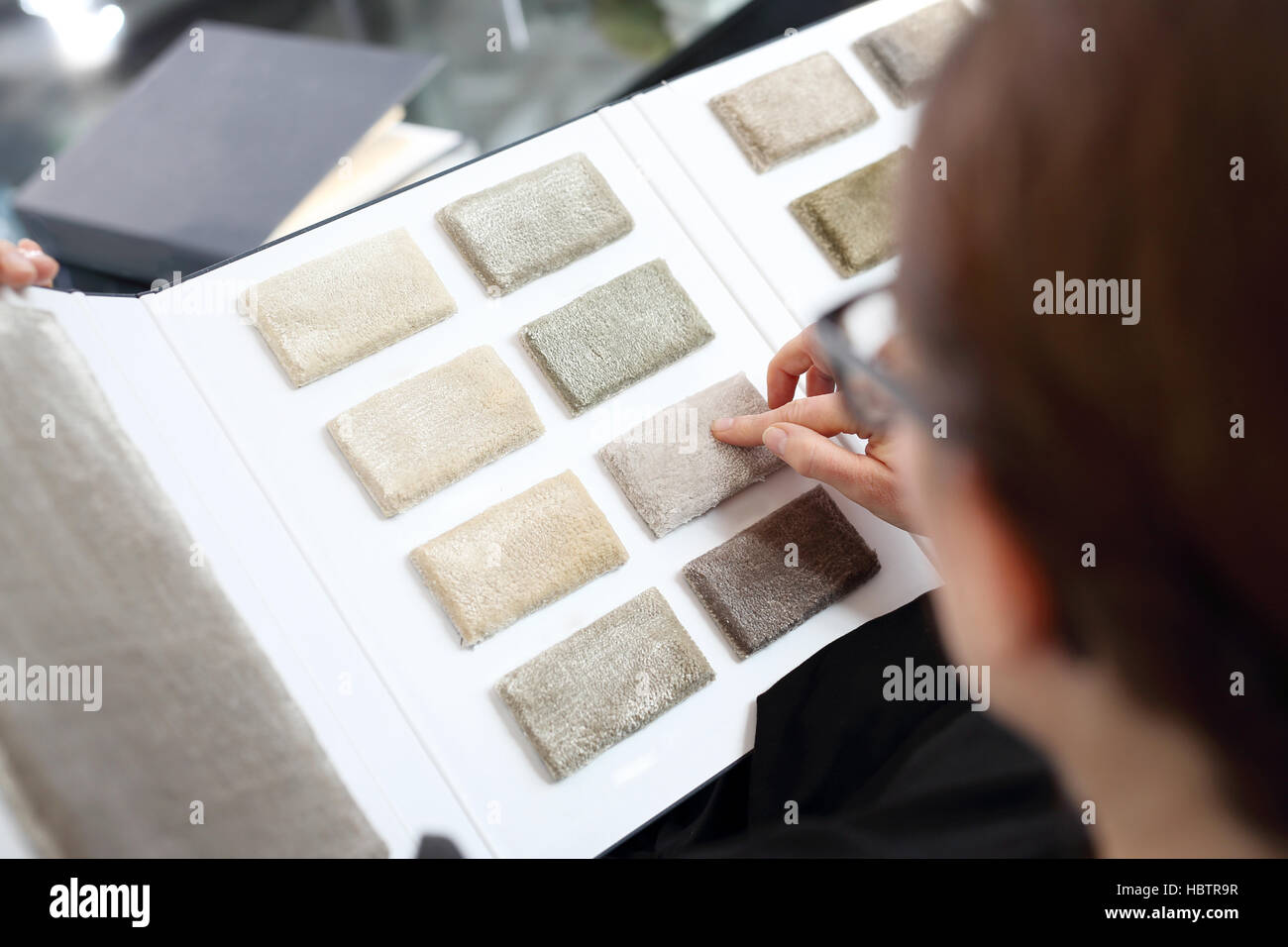 Shop carpets. Picker carpet. Woman in shop with carpets chooses carpet ...