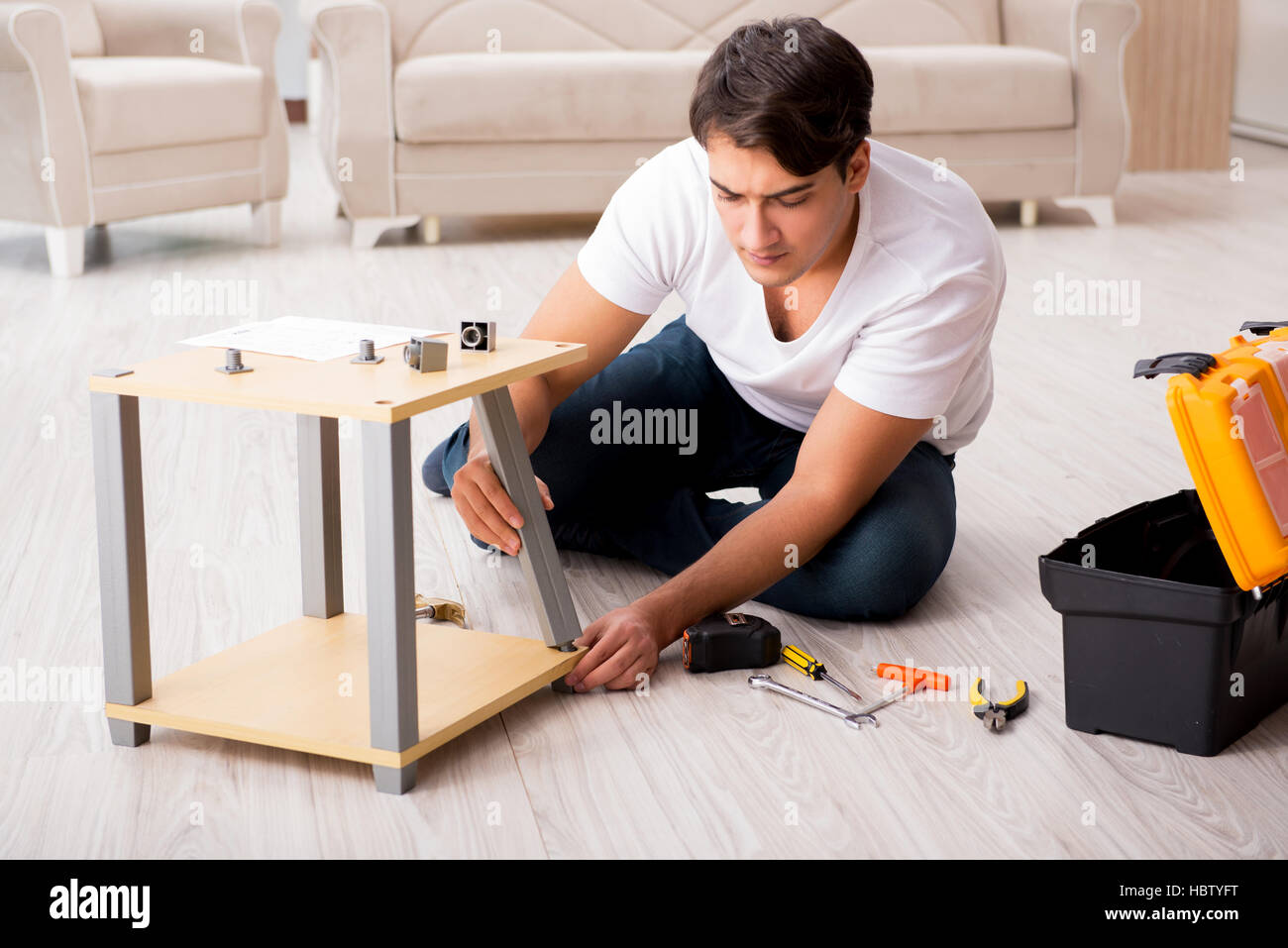 Man assembling shelf at home Stock Photo - Alamy