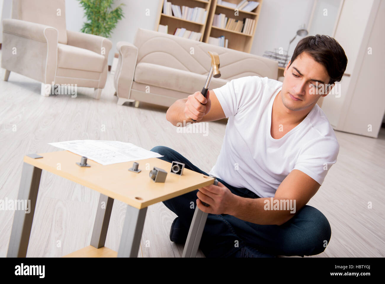 Man assembling shelf at home Stock Photo - Alamy