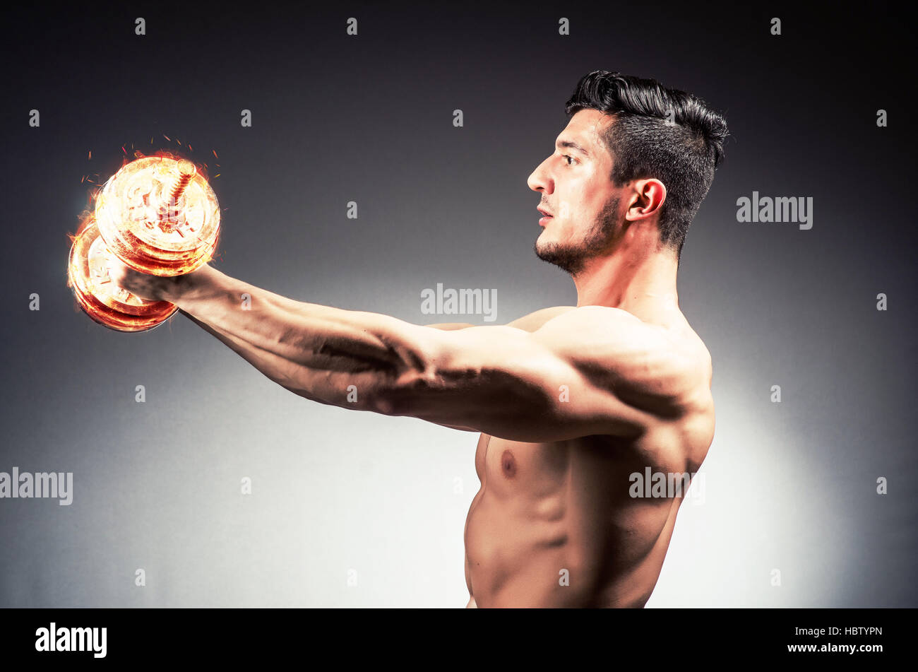 Muscular ripped bodybuilder with burning dumbbells Stock Photo - Alamy