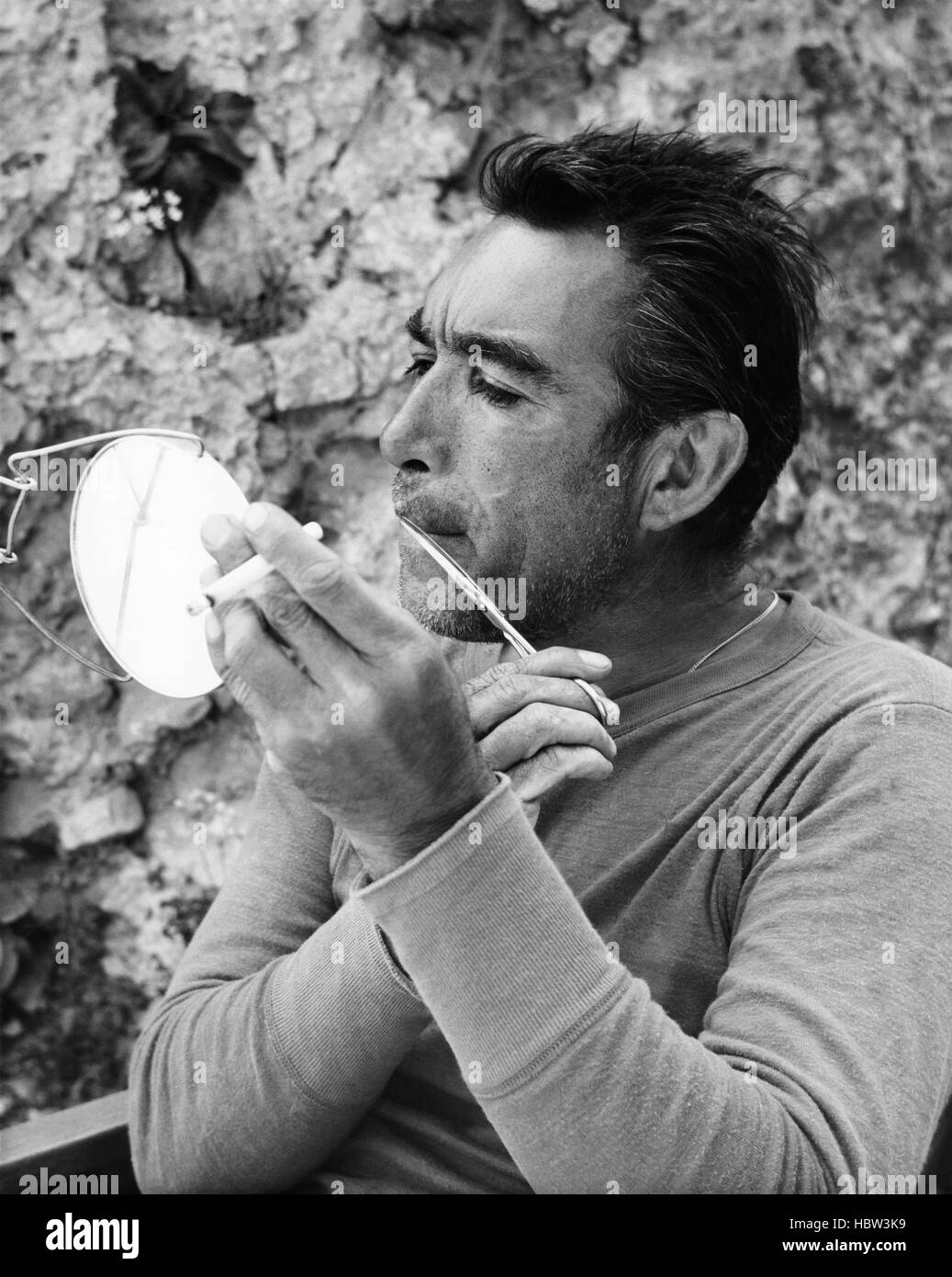 THE GUNS OF NAVARONE, Anthony Quinn trims his moustache, between scenes ...