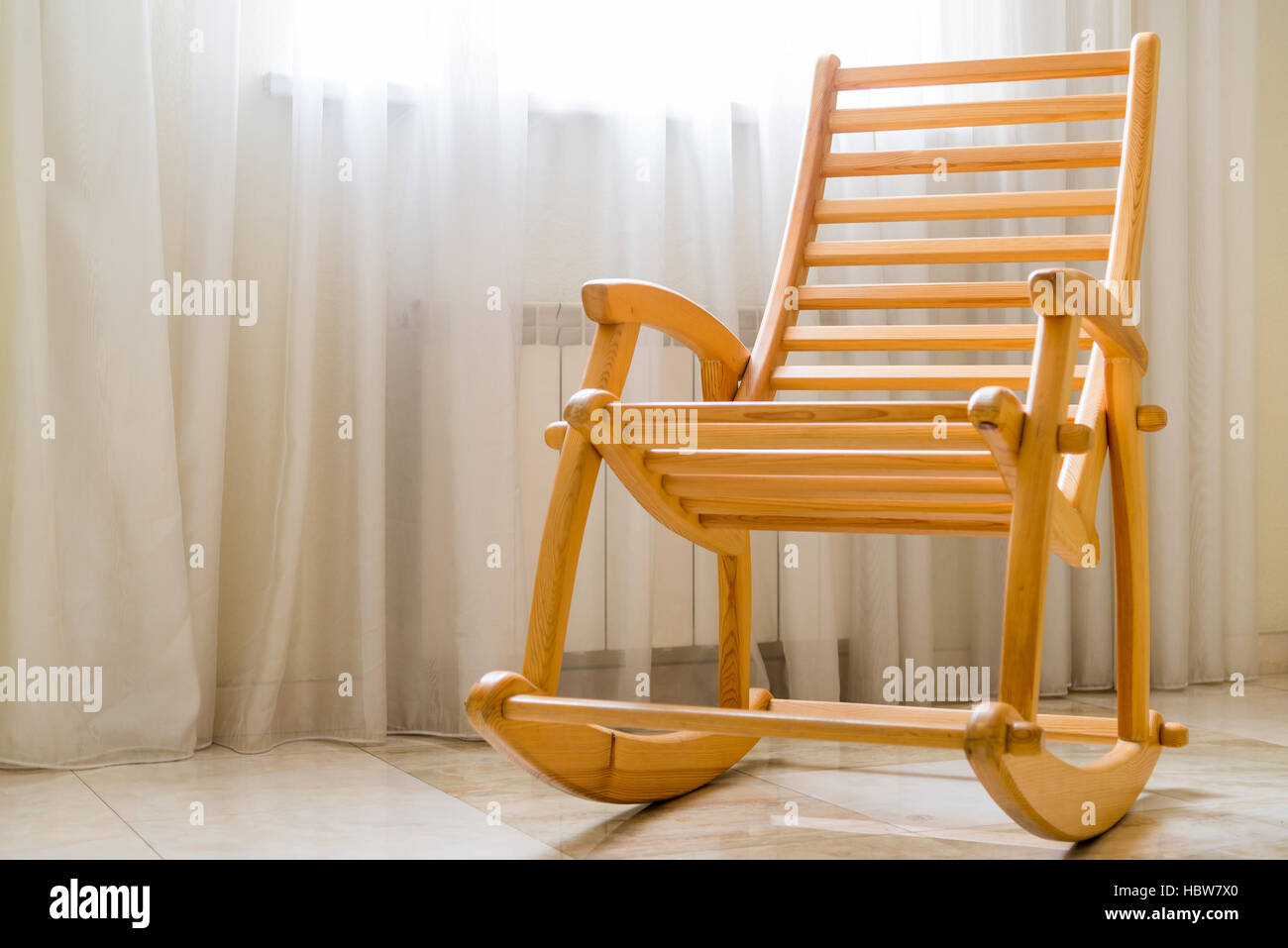Wooden rocking chair near the window in room Stock Photo - Alamy