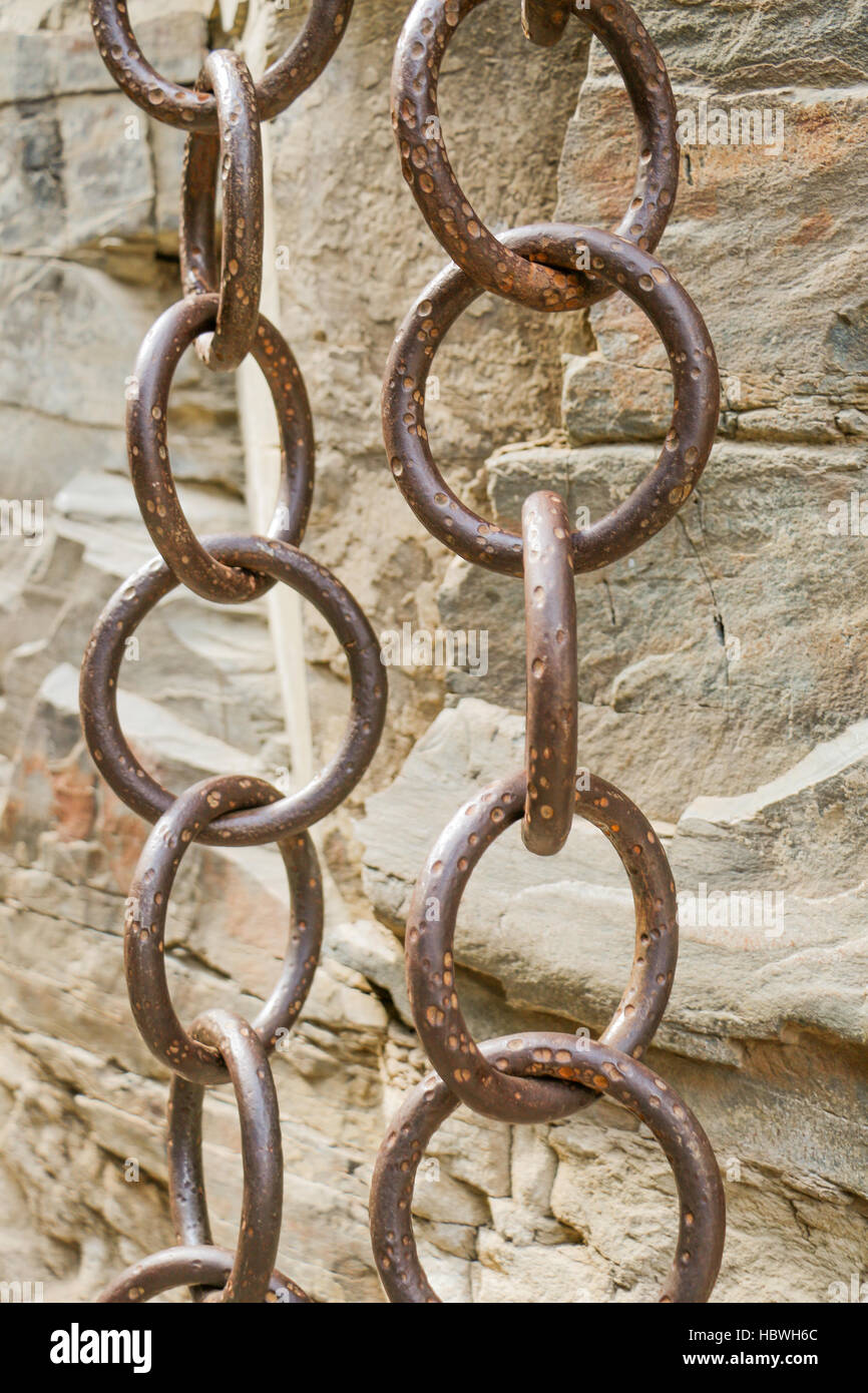 Matal chain pairs hanging by the side of a rock side Stock Photo - Alamy
