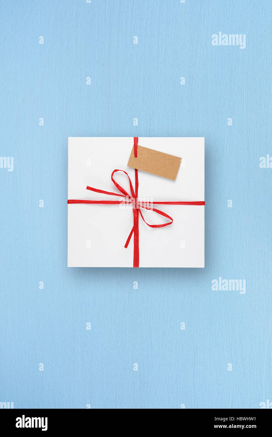 White gift box with blank tag on blue table Stock Photo - Alamy