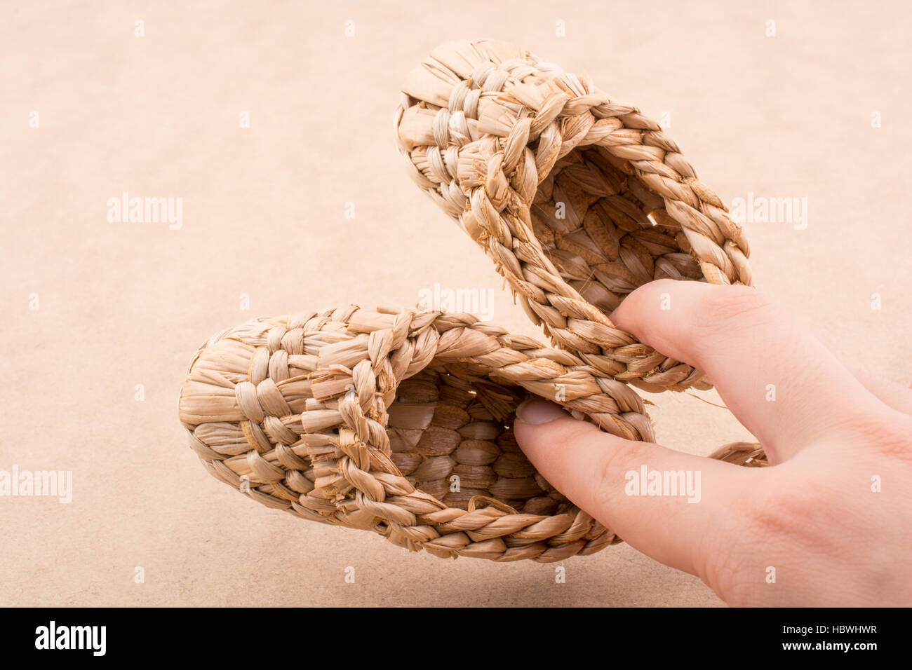 Pair of brown color straw shoes hand on a brown background Stock Photo ...