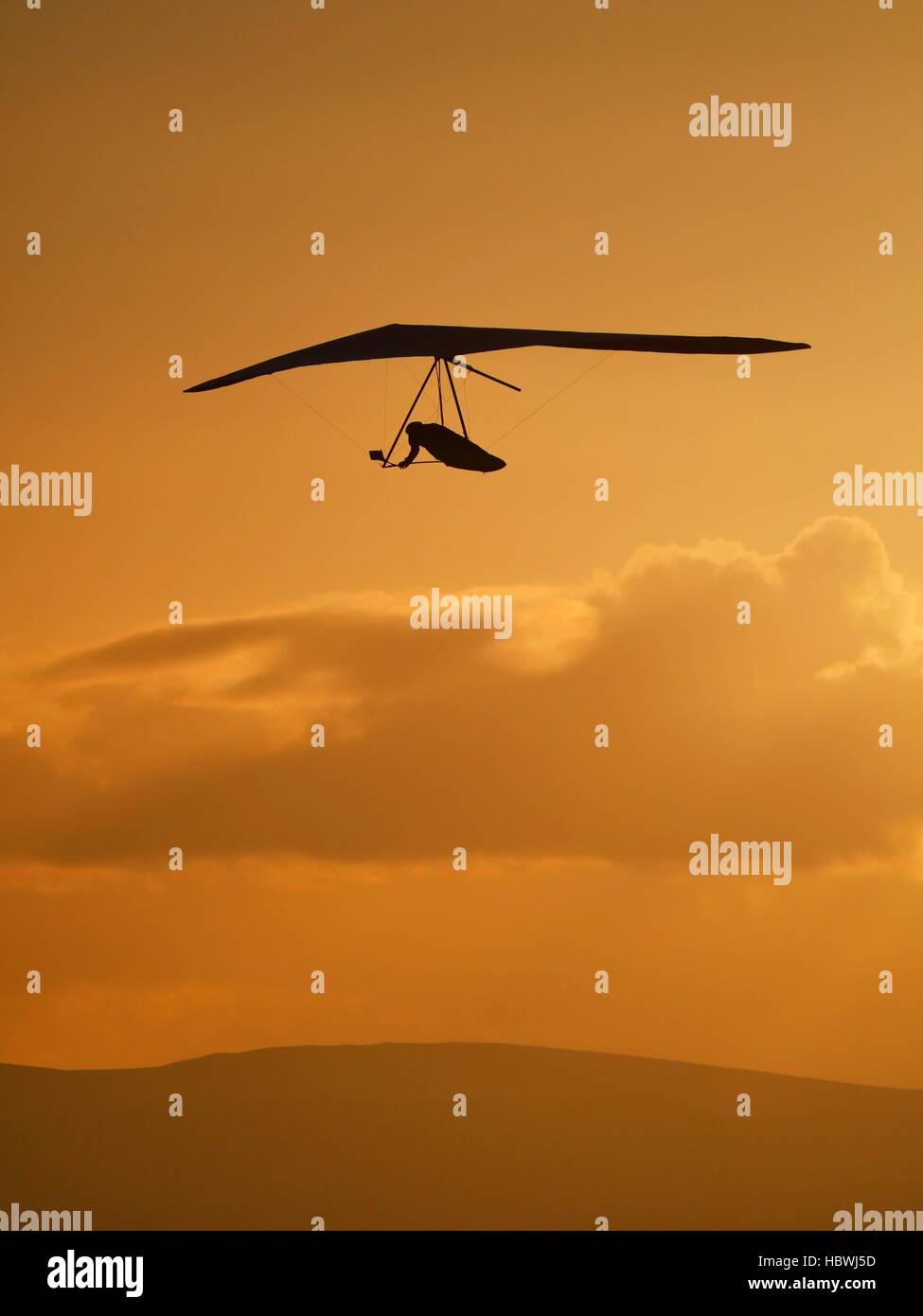 Hang glider flying against sunset sky Stock Photo - Alamy