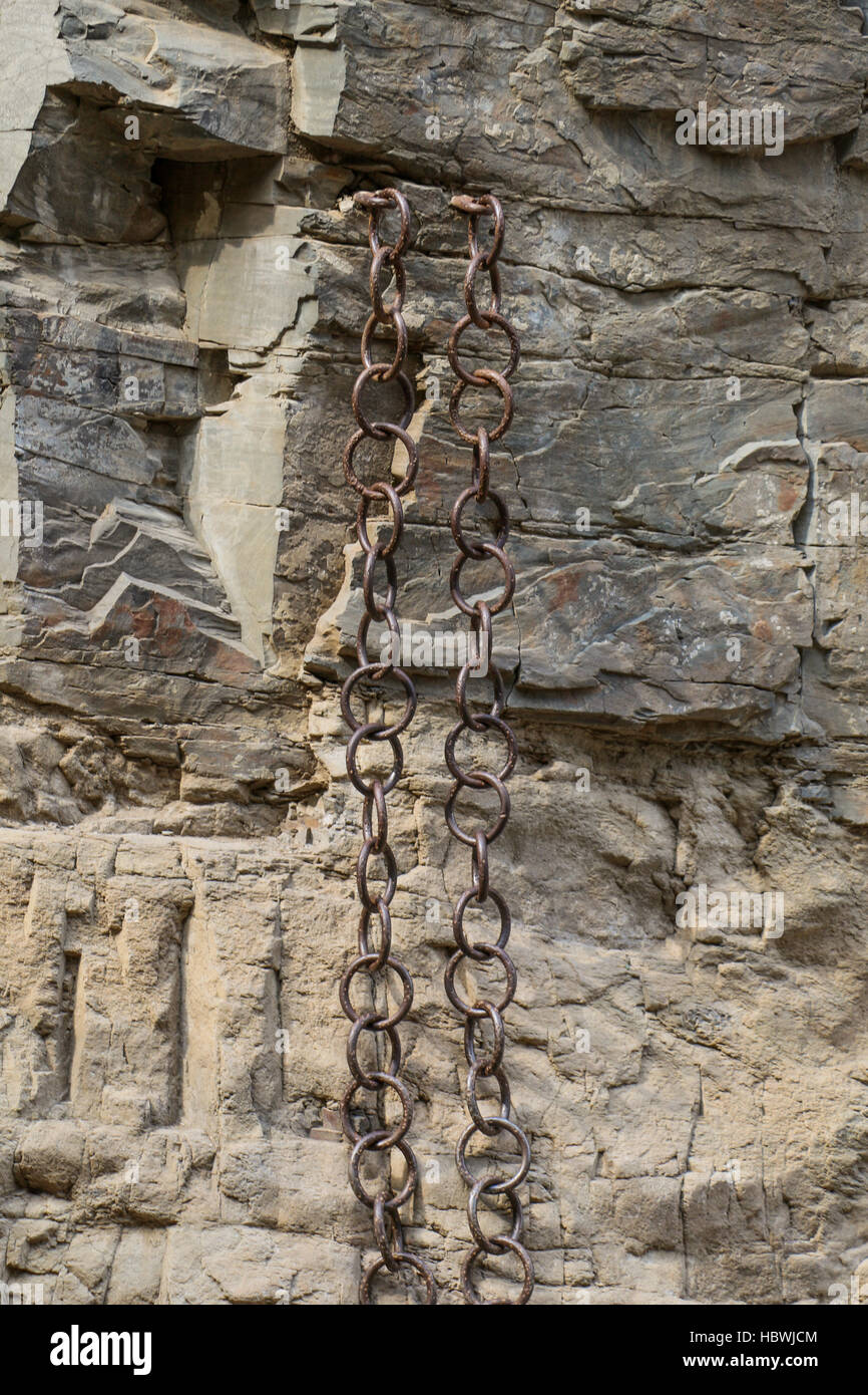 Matal chain pairs hanging by the side of a rock side Stock Photo - Alamy