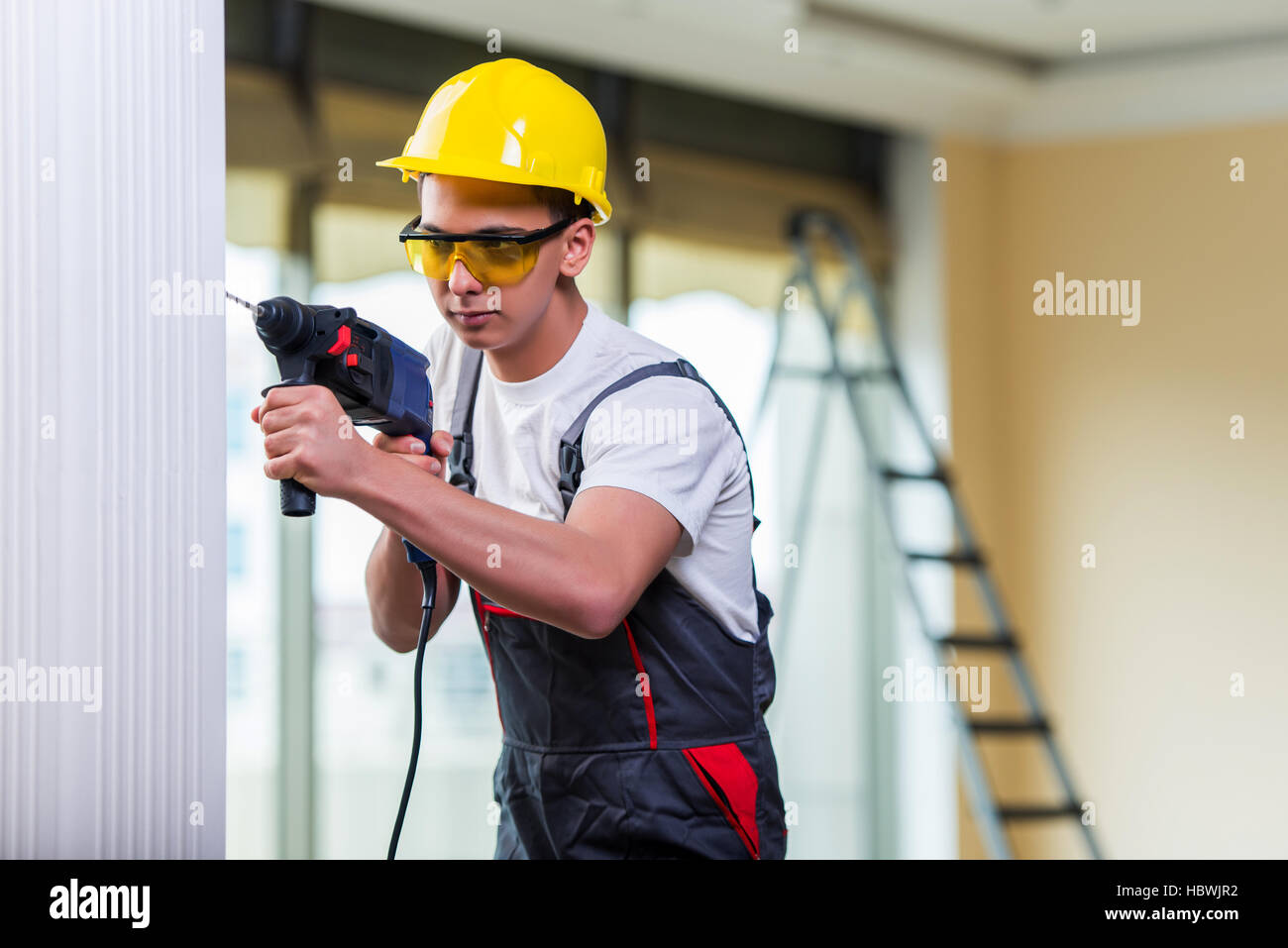 Man drilling the wall with drill perforator Stock Photo - Alamy