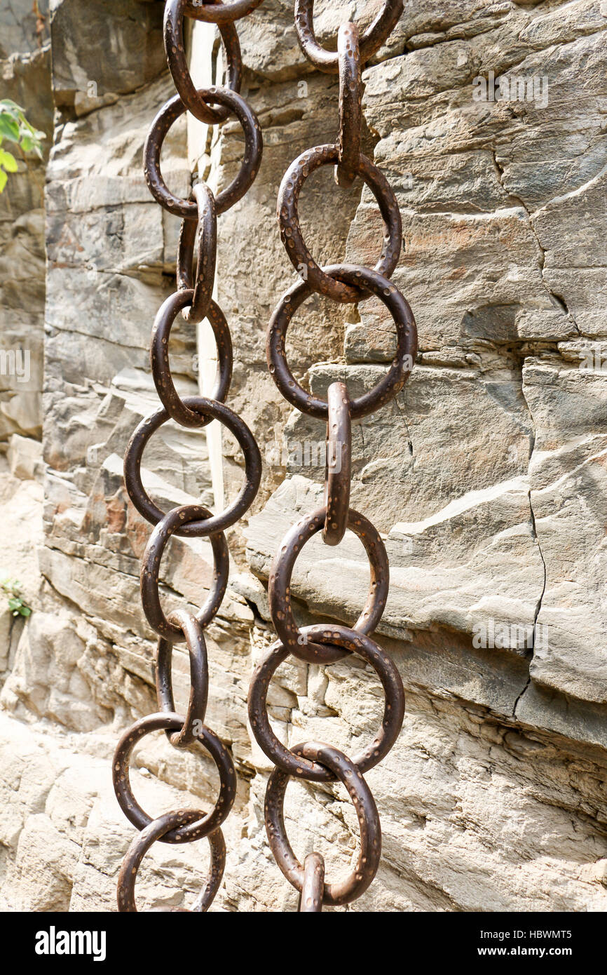 Matal chain pairs hanging by the side of a rock side Stock Photo - Alamy