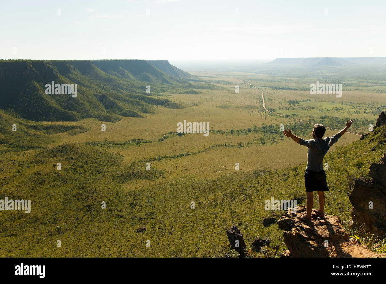 A young man with open arms wide against the wind admires the amazing ...