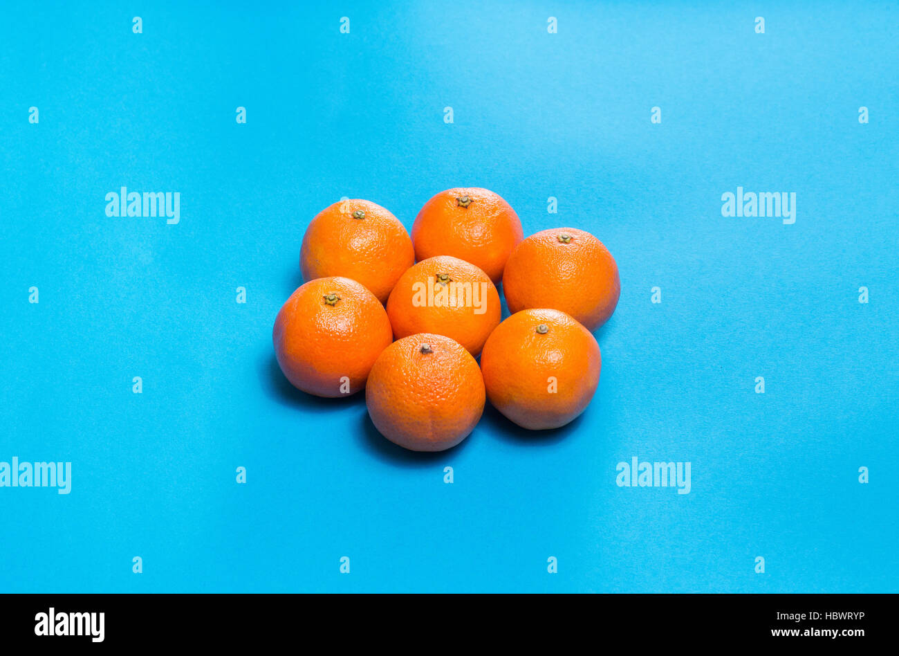 Sun symbol from Six Colorful fresh orange mandarins laid out on blue ...
