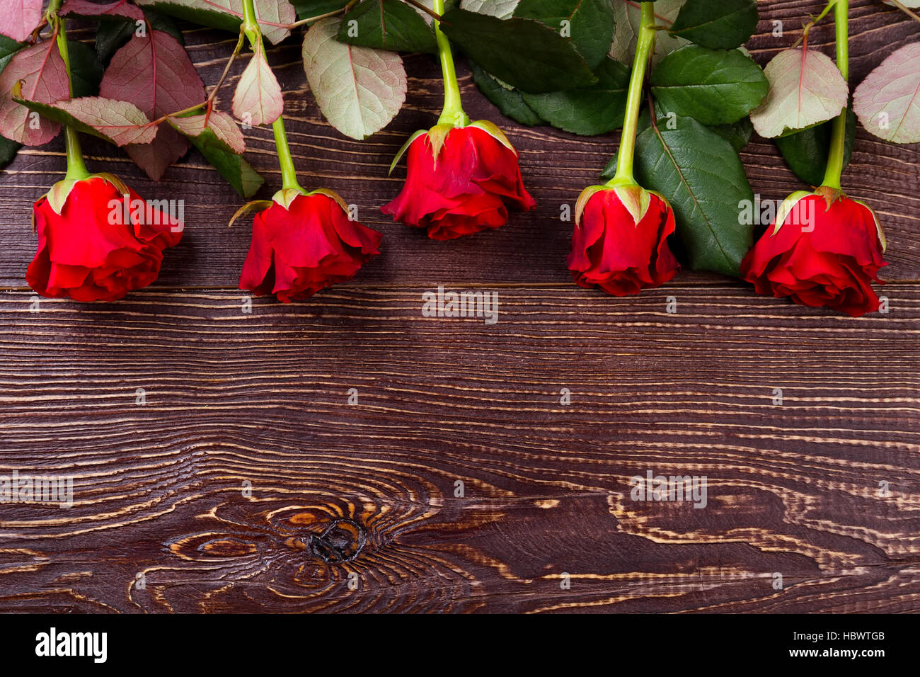 Red roses on wooden background Stock Photo - Alamy