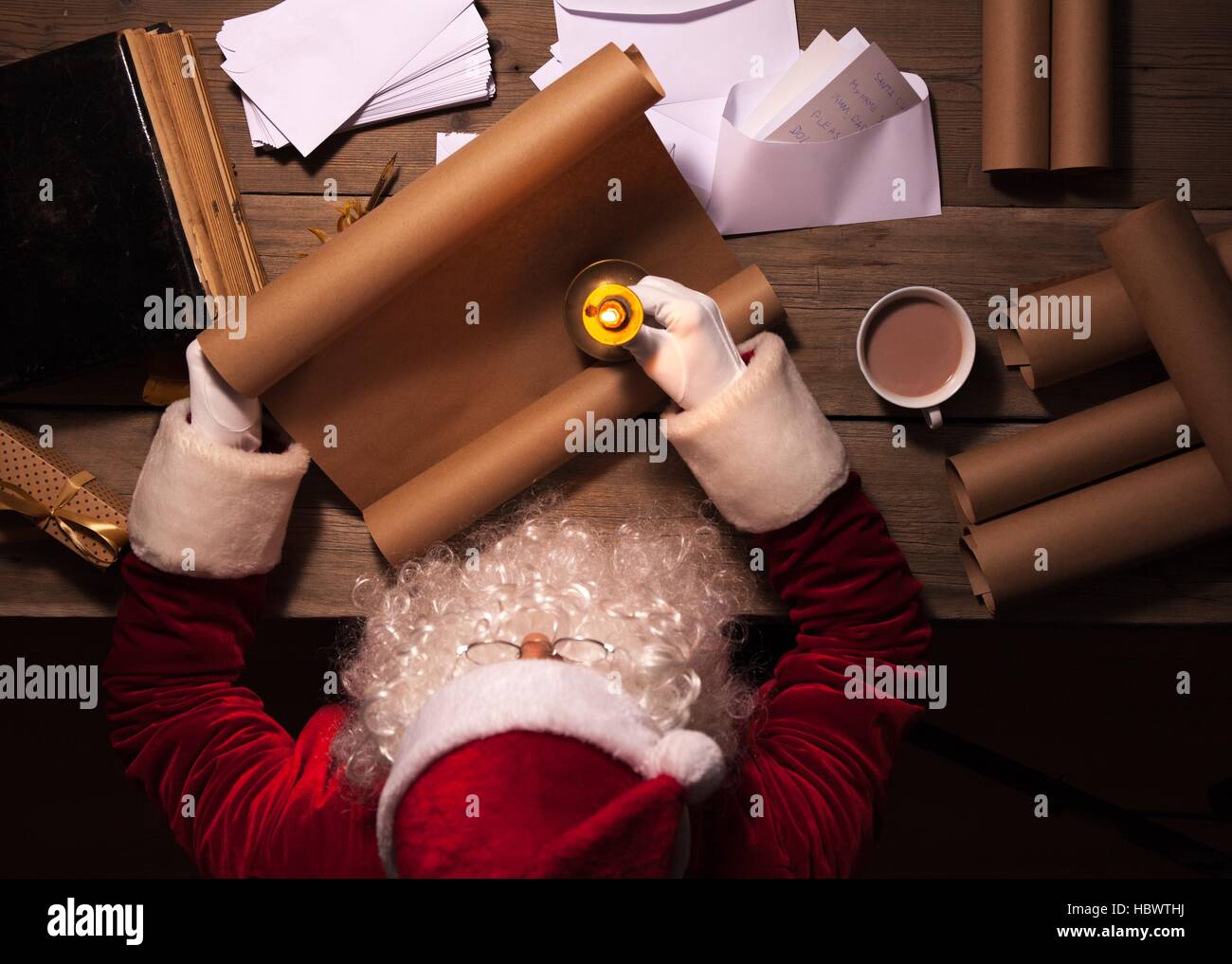 Santa Claus sitting at the table in his room and reading Christmas ...