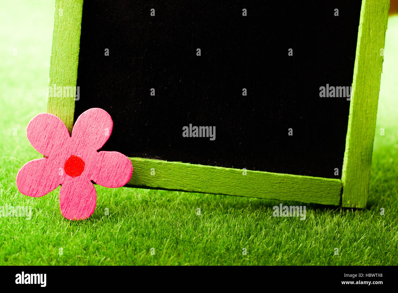 Blackboard with floral icon placed on green grass ground Stock Photo ...
