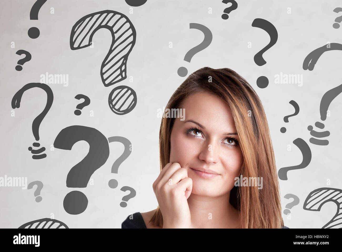 Woman wondering, with question marks around her Stock Photo - Alamy