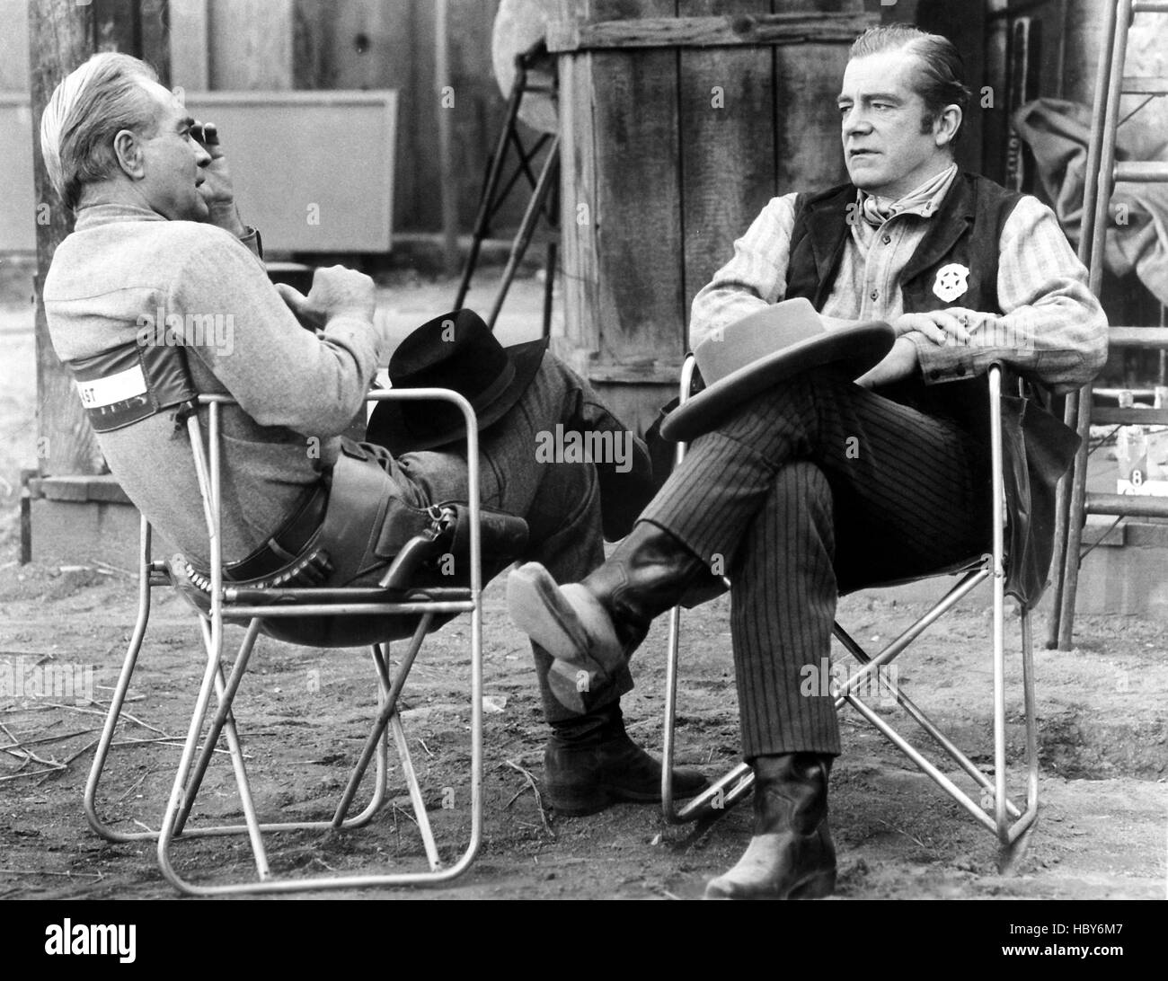 JOHNNY RENO, Lyle Bettger, Dana Andrews, relax on the set, between ...