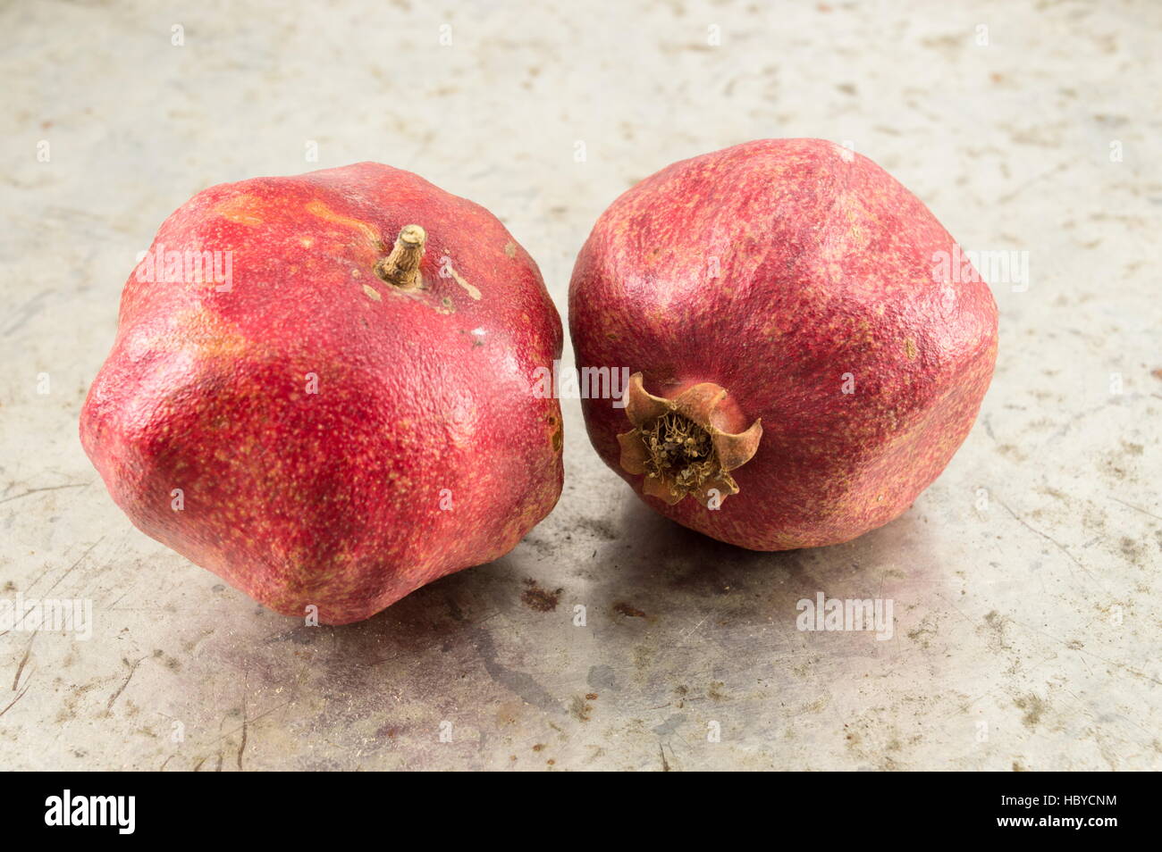 two whole ripe pomegranates on a rustic backrgound Stock Photo - Alamy