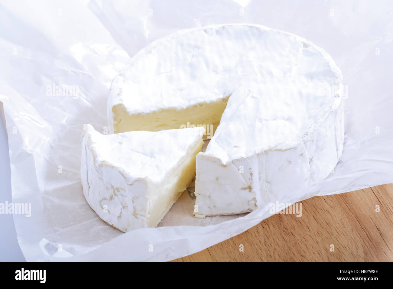 Camembert in paper, cut Stock Photo - Alamy