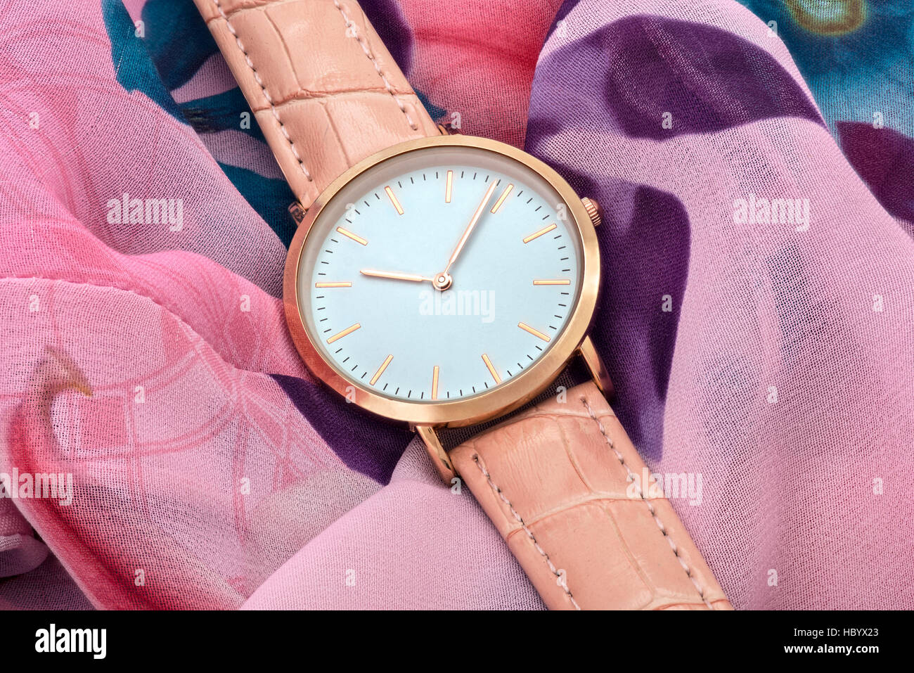 Pink wrist watch on colourful silk fabric background Stock Photo - Alamy