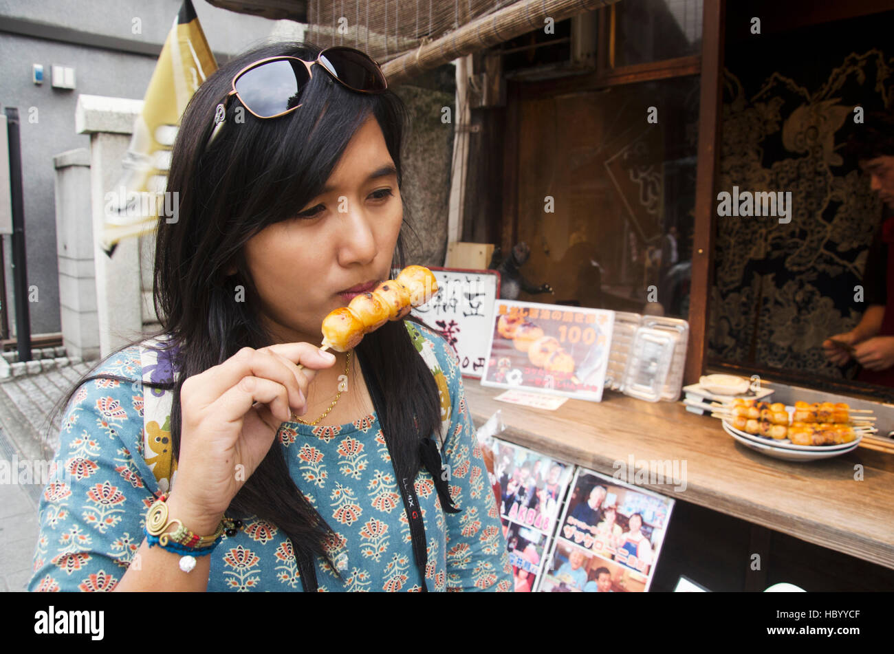 Traveler thai woman eating Mitarashi Dango japanese snack style at ...
