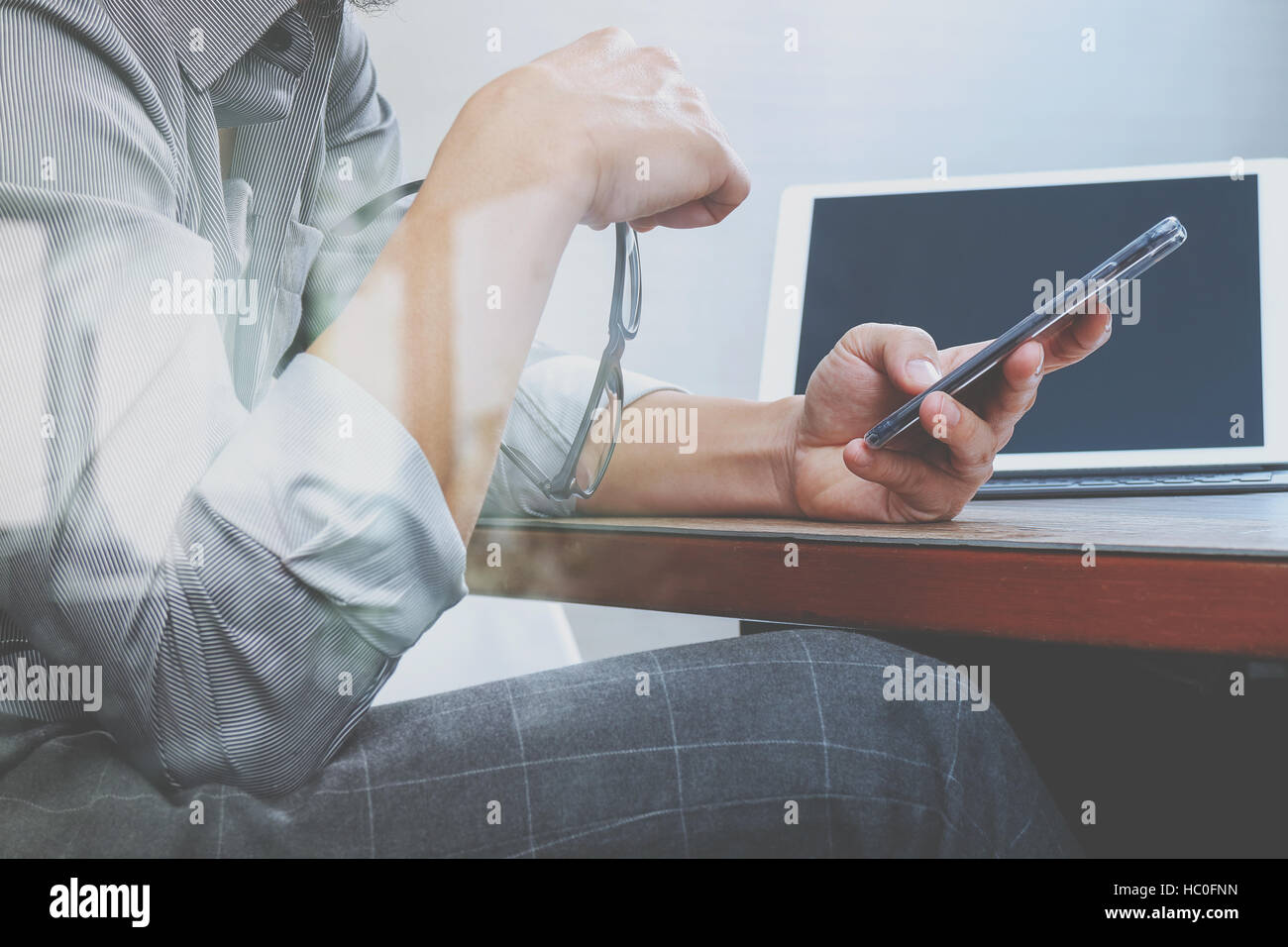 success businessman hand using eyeglass,smart phone,digital tablet docking smart keyboard on ...