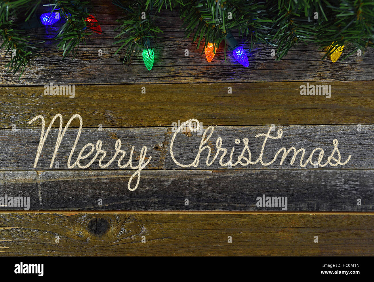 Merry Christmas in rope design with glowing Christmas lights on rustic ...