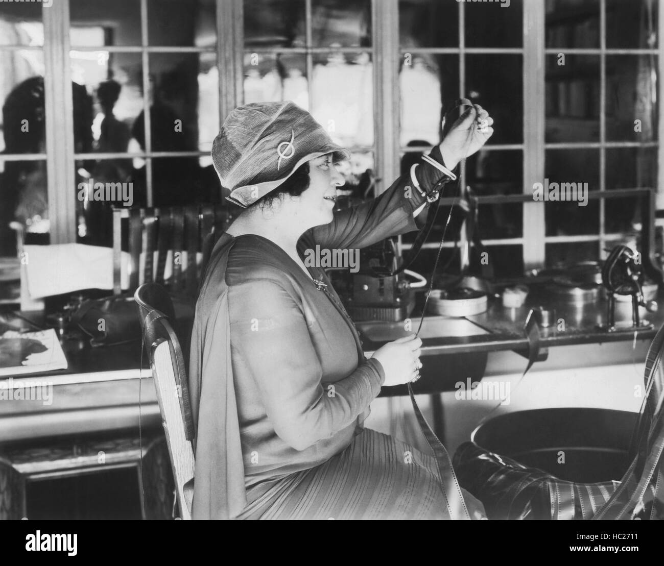 THE MASKED WOMAN, producer June Mathis examining the film in the lab ...
