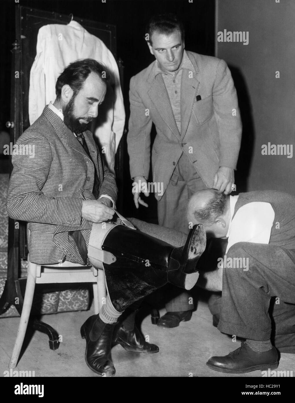 MOULIN ROUGE, Jose Ferrer, being strapped into prosthetic legs ...