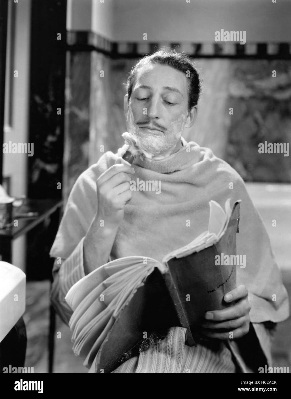 THE MOUTHPIECE, Warren William studying script and shaving in his ...