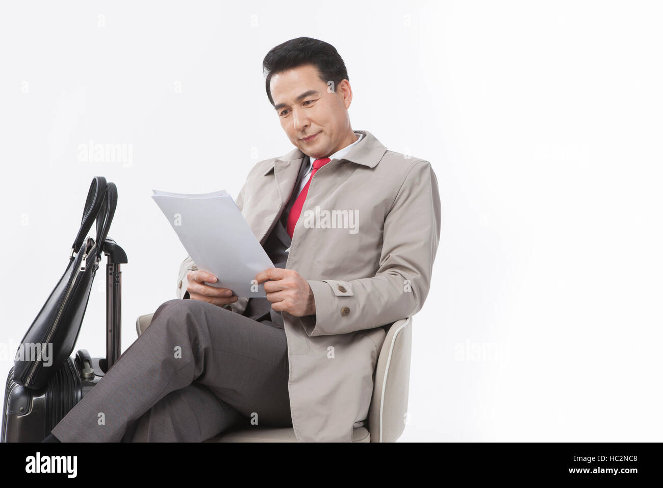 Smiling middle aged man holding and looking at paper with carrier Stock ...