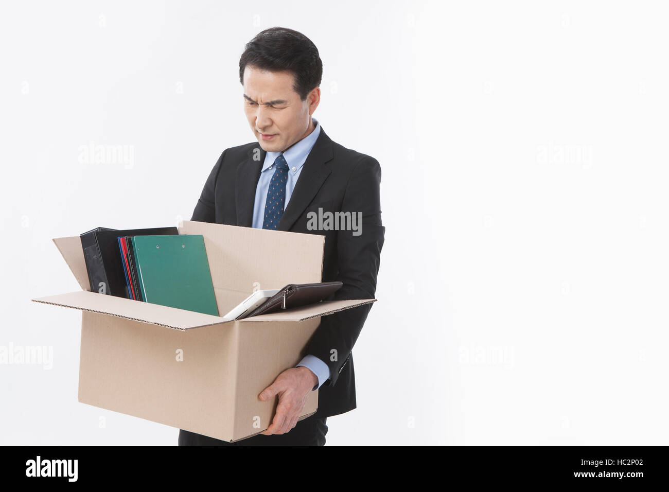 Middle aged businessman carrying files in a box frowning his face Stock ...
