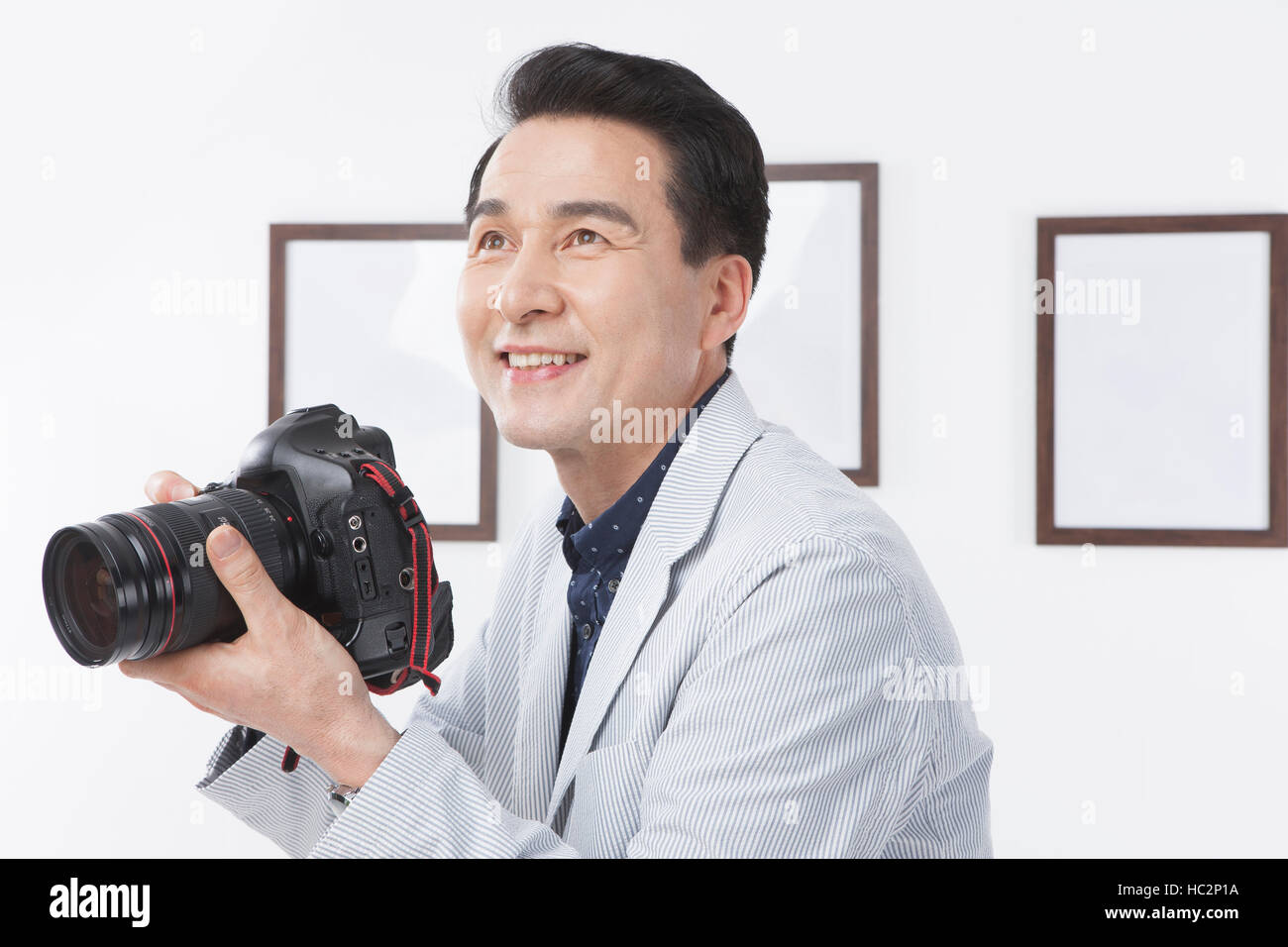 Asian man looking picture frame hi-res stock photography and images - Alamy