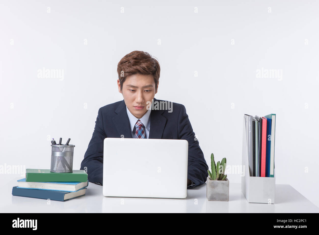 Young businessman using notebook computer frowning his face at work ...