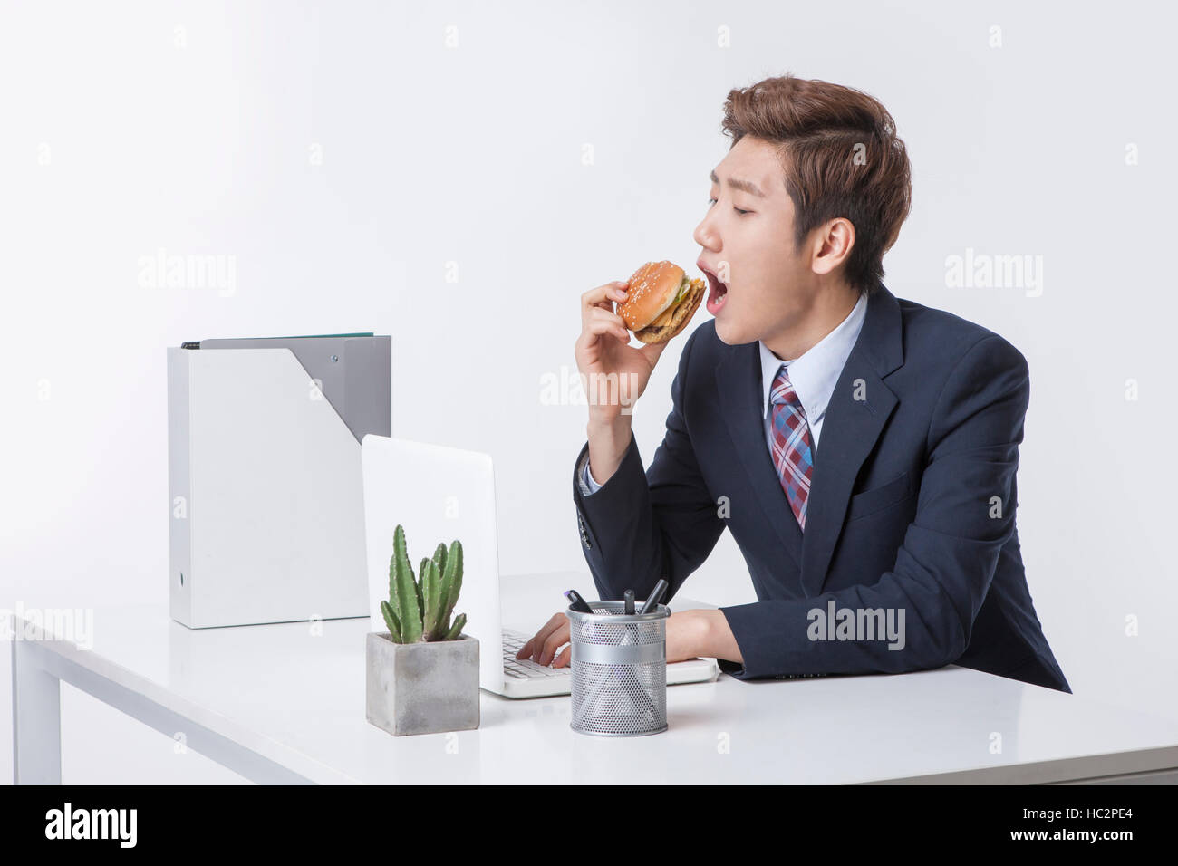 Man eating hamburger sitting table hi-res stock photography and images ...