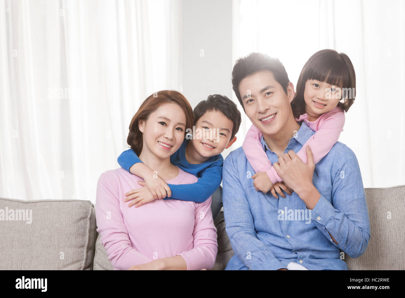 Harmonious family posing at sofa Stock Photo - Alamy
