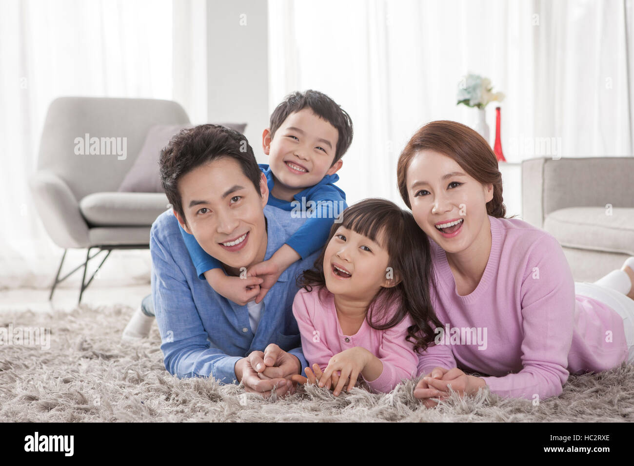Harmonious family resting on a rug in living room Stock Photo - Alamy